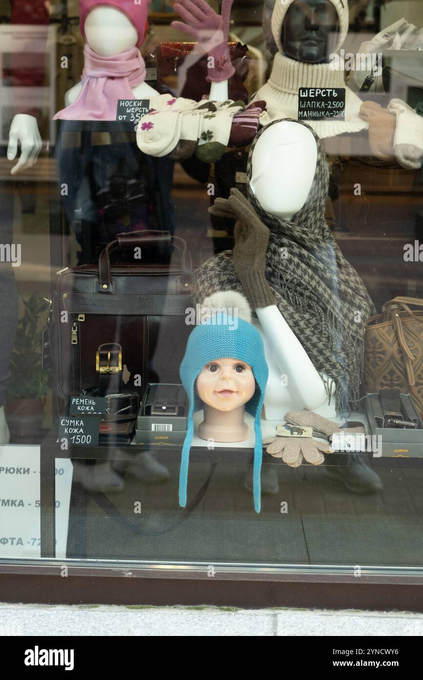 A mannequin head wearing a bright blue knit hat with long strings ...