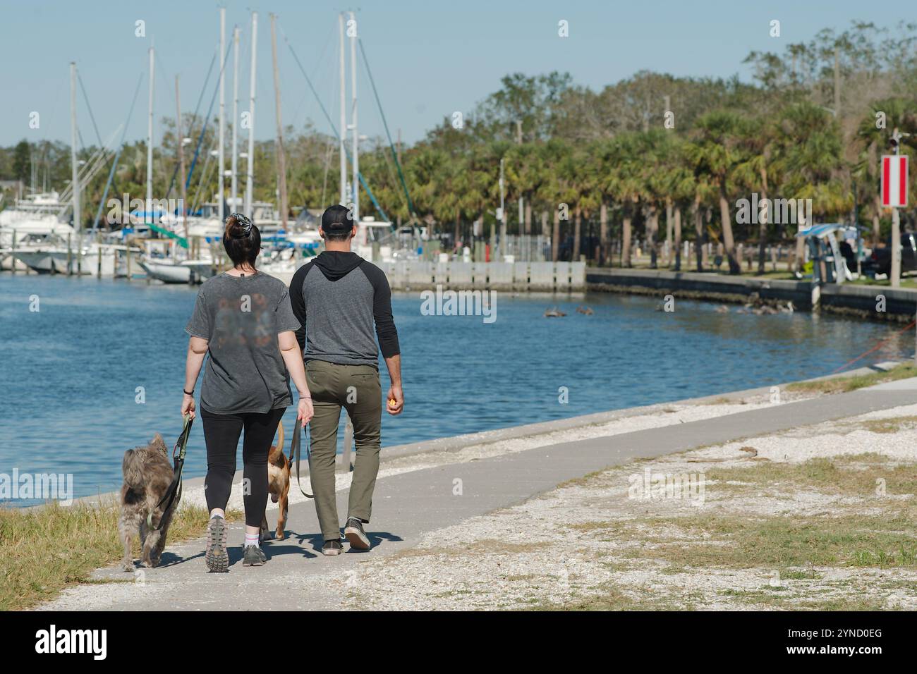 Couple man and woman walking away on left side sidewalk leading lines ...
