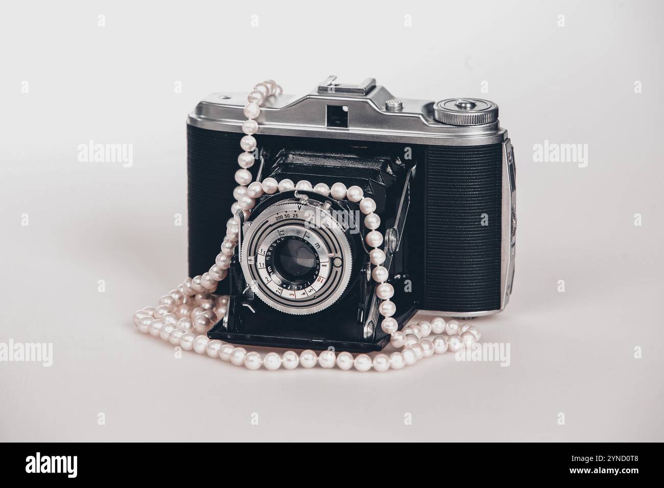 old 20th century photo camera with retractable lens on light background ...