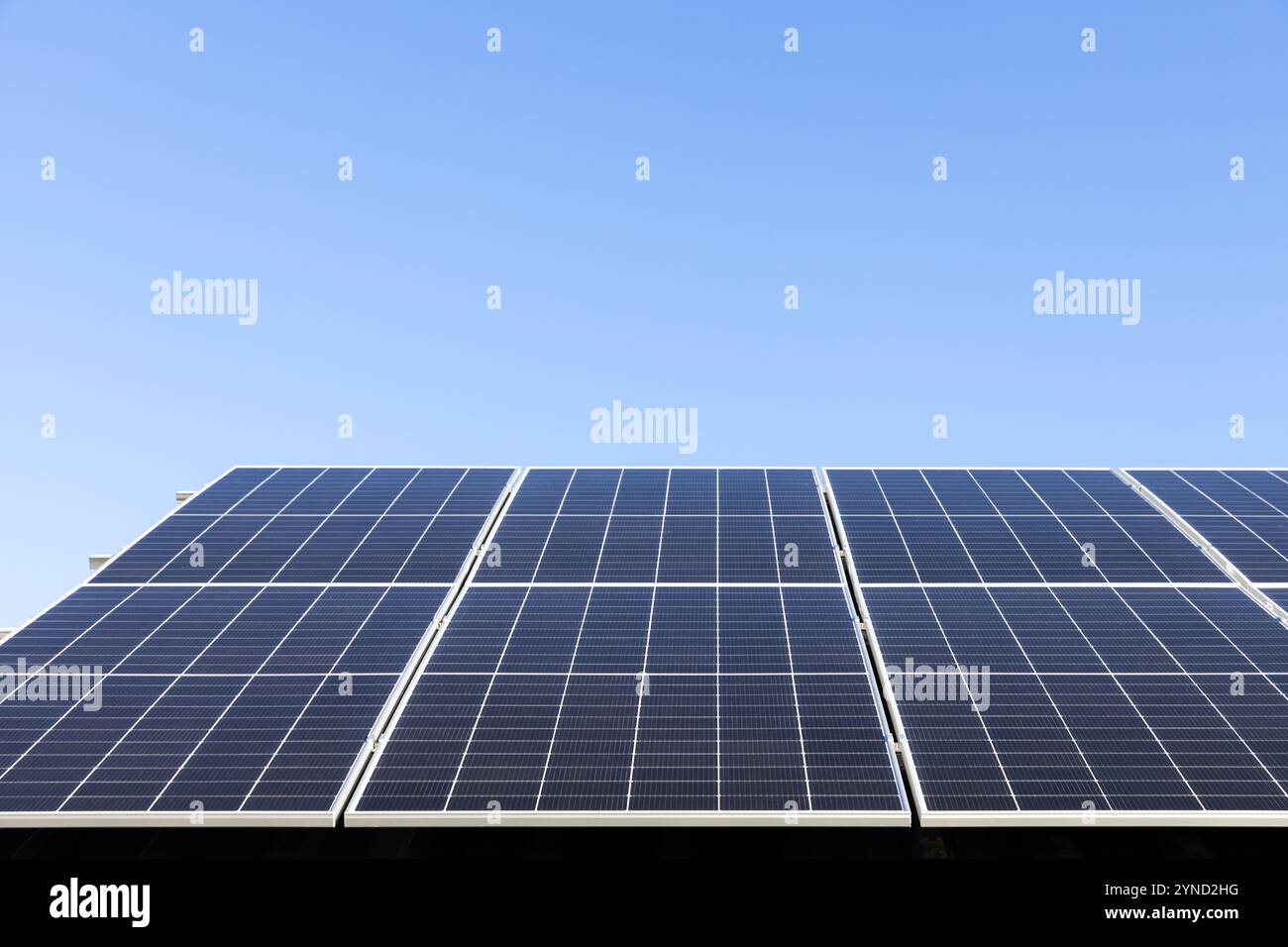 Aerial view of solar panel cells on clear blue sky background ...