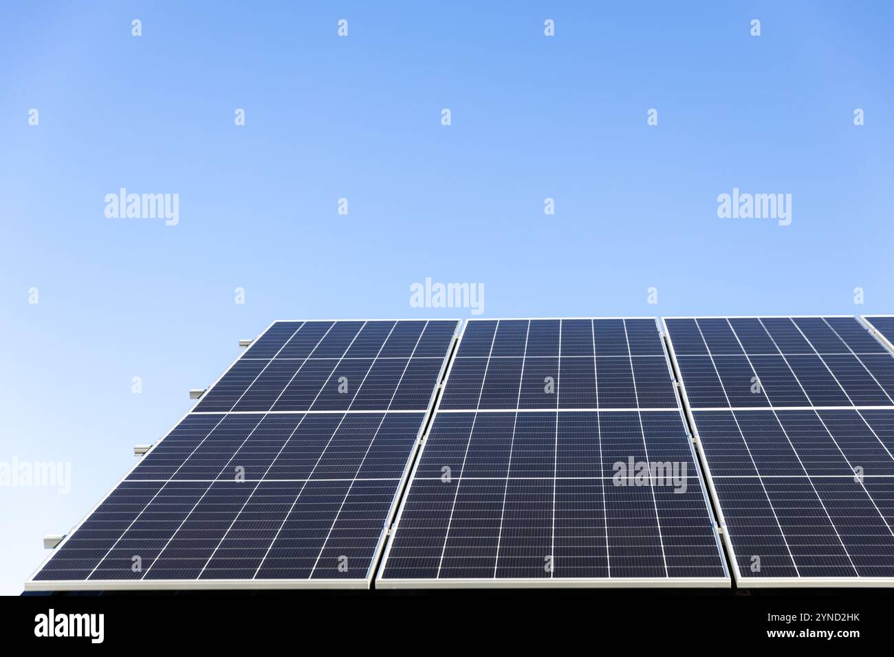 Aerial view of solar panel cells on clear blue sky background. Clean ...