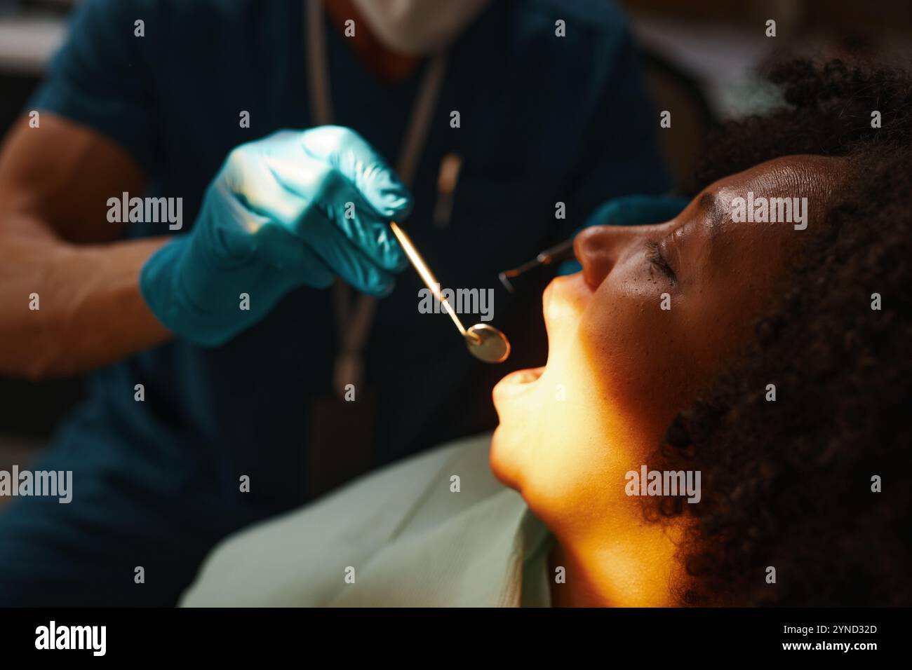 Dentist performing oral examination of Black person, inserting dental ...