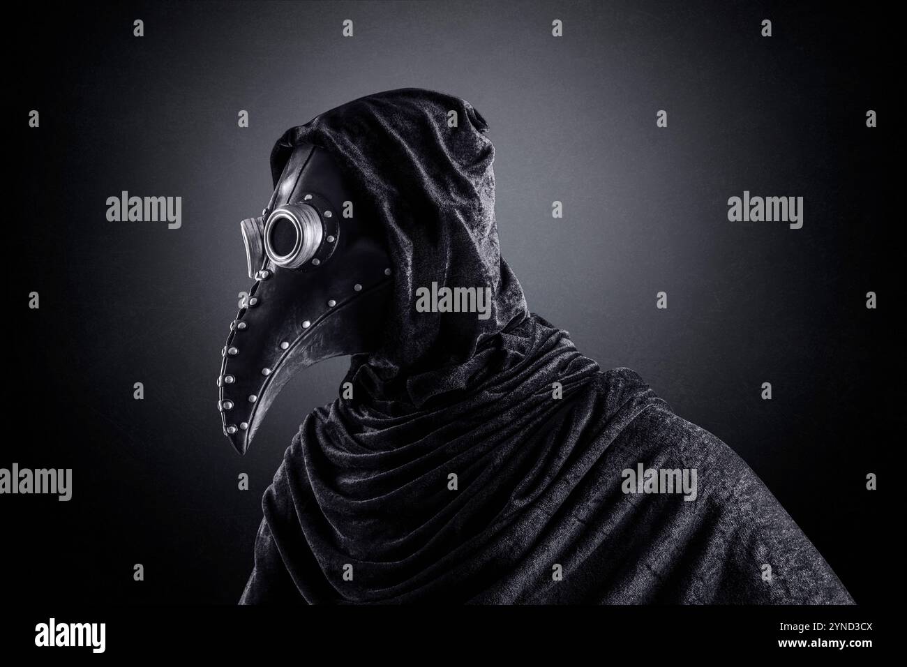 Plague doctor in hooded cloak at night over dark misty background Stock ...