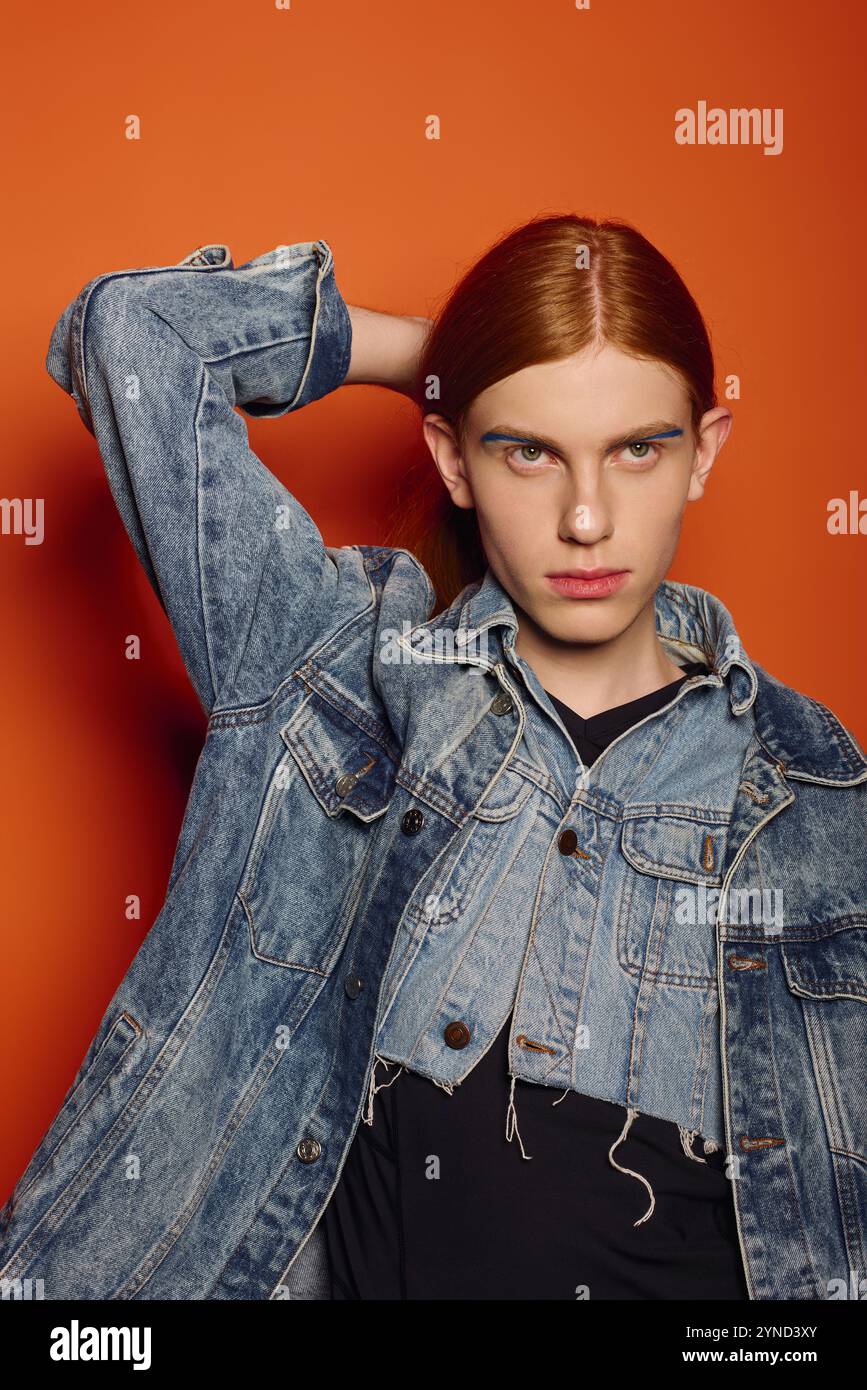 Young man with striking long red hair shows deep emotion while posing ...