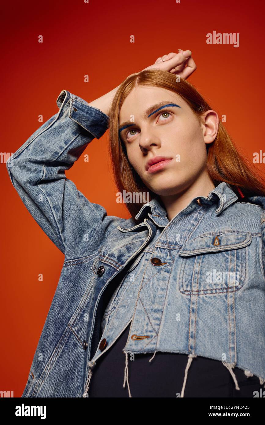 Young man with striking long red hair expresses deep emotions while ...