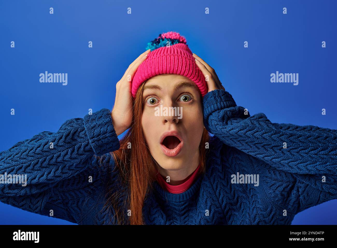 Emotional young man with long red hair shows shock while wearing a ...