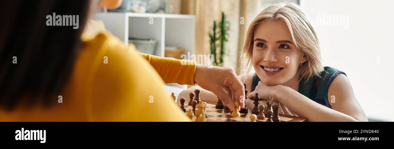 Two young women smile and engage in a playful chess game in a bright ...