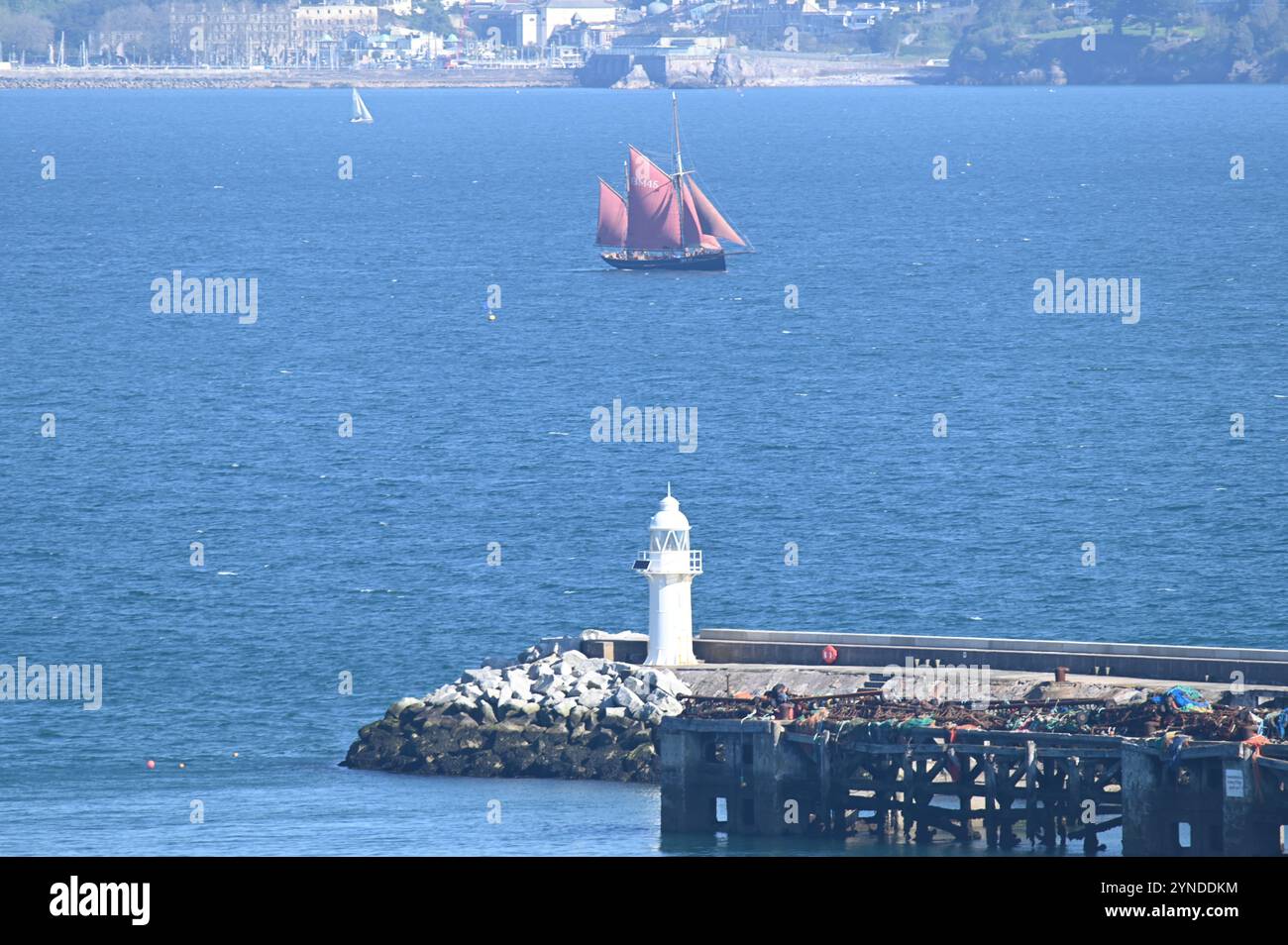 A traditional Brixham sailing trawler sets off on a calm morning in ...