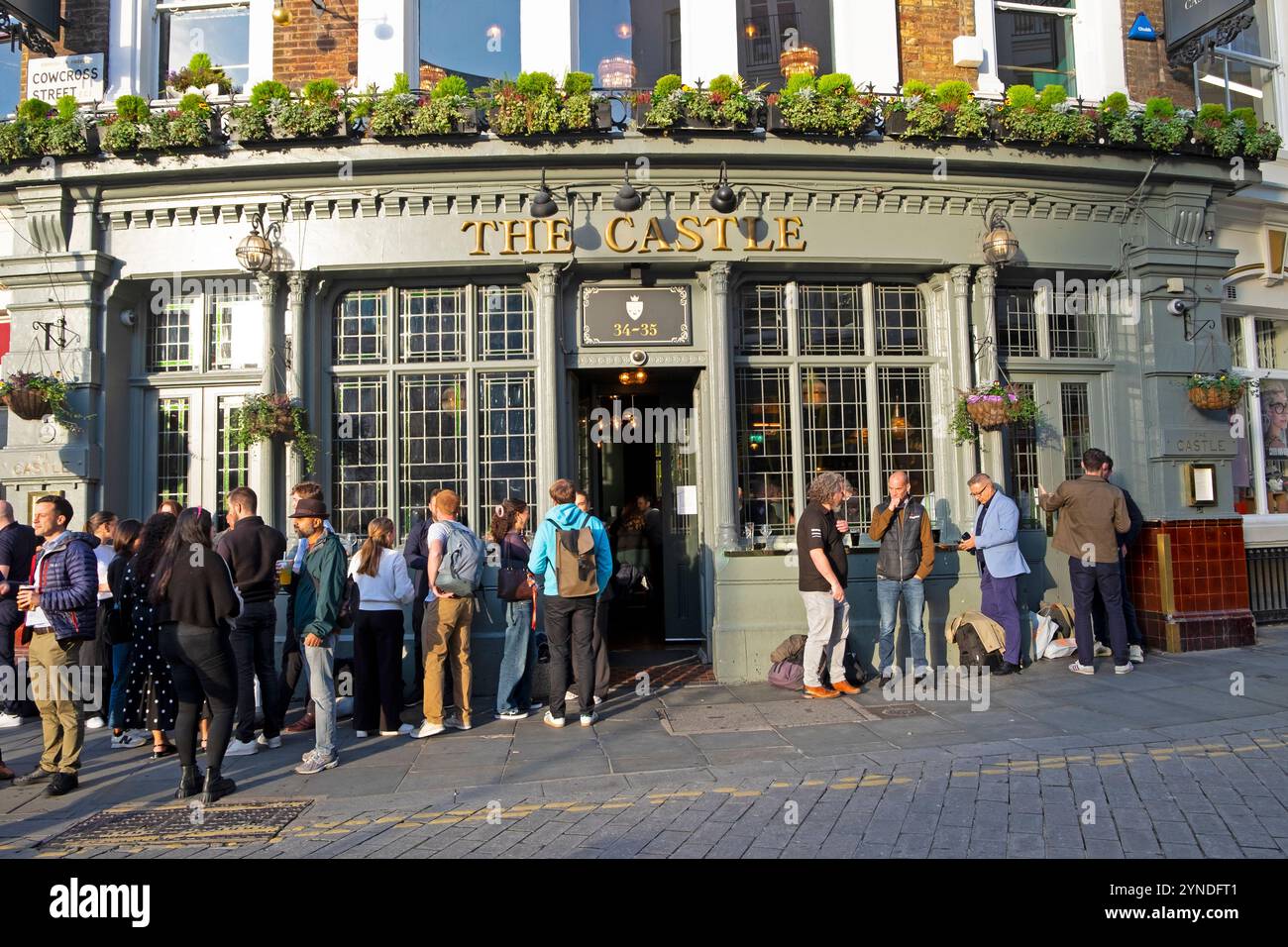 People standing drinking beer outside The Castle pub after work on ...