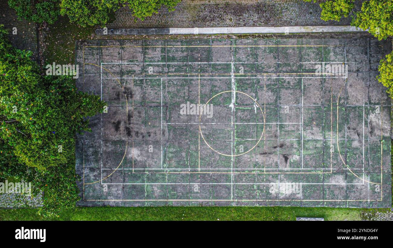 Aerial top-down photo of multisport court degraded by time in a tree ...