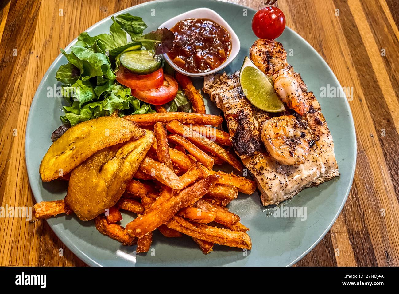 Grilled fish fillet with shrimps, Creole sauce and funchi fries (fried ...