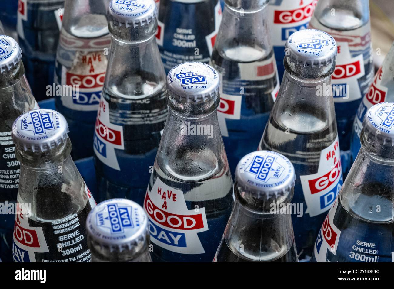 Soft drinks in glass bottles displayed on shelf for sale in a shop ...
