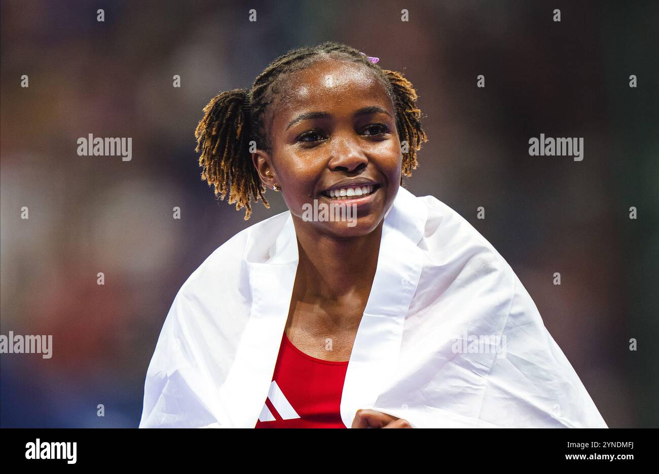 Winfred Yavi celebrating her medal with her country's flag at the Paris ...