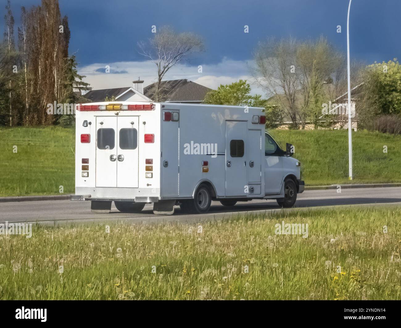 A rear view of a plain white ambulance traveling on the road Stock ...