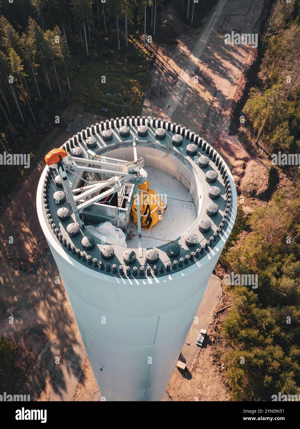 View of a wind turbine under construction in a dense forest area ...