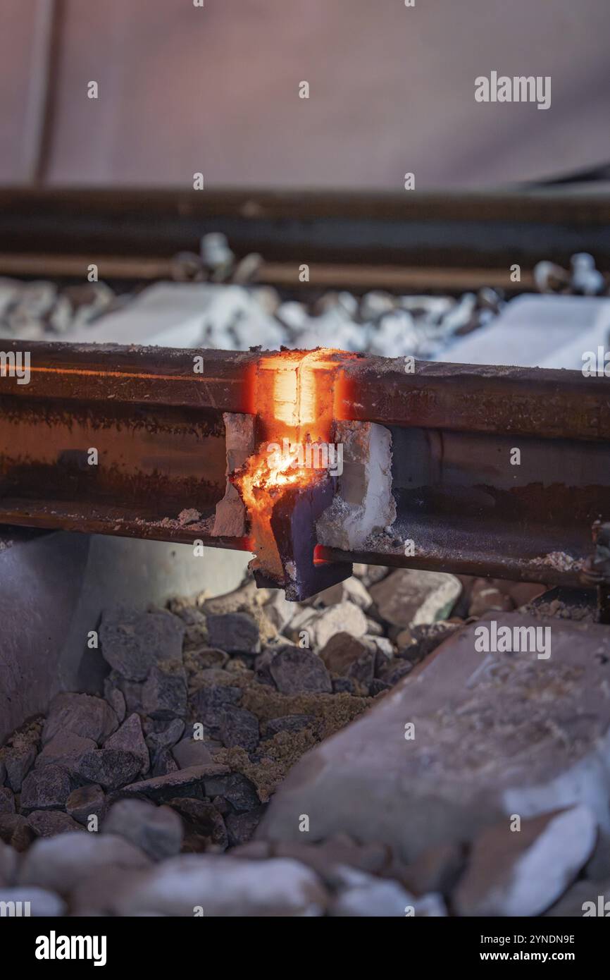 Welding work on a rail interface with molten metal and glowing heat ...