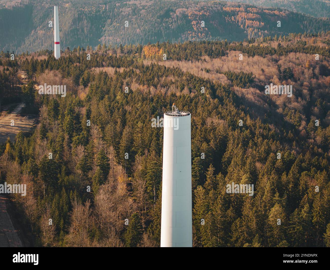 View of a wind turbine above the autumnal forests of the hills, wind ...
