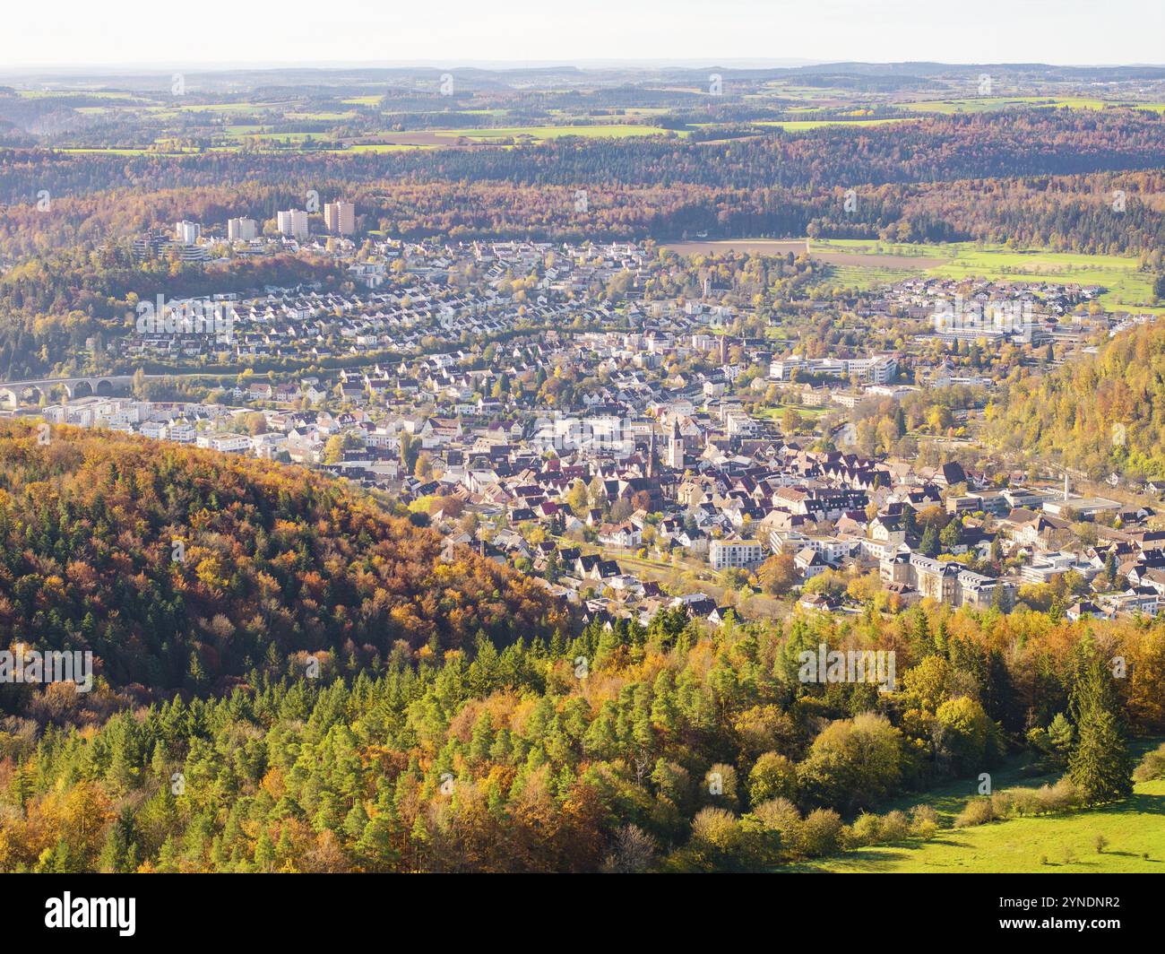 View of a town on the edge of an autumn-coloured forest, visible from ...