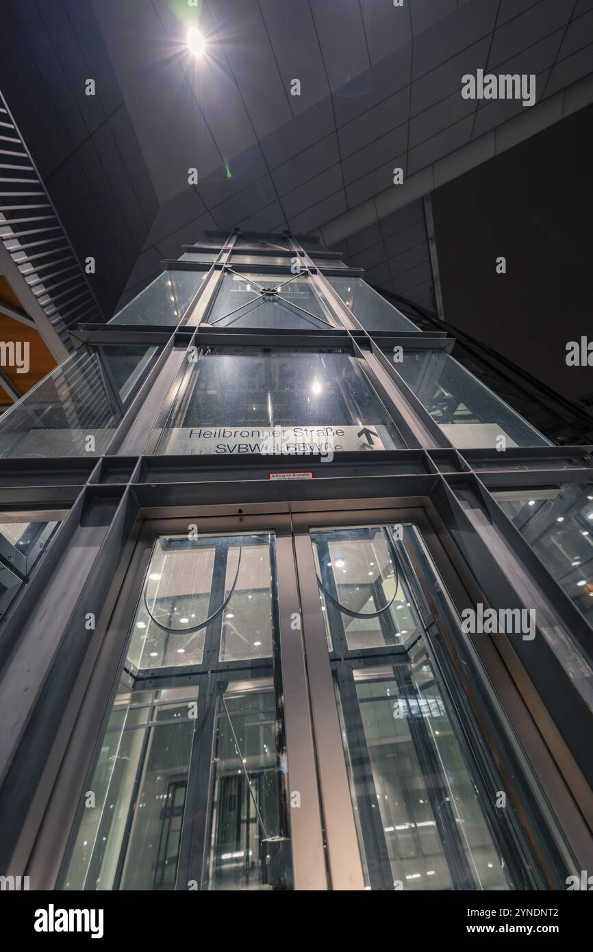 Modern glazed lift at night, integrated into the lighting of a building ...