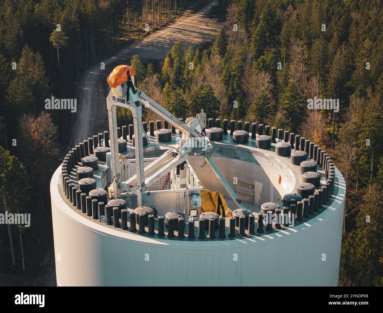 Close-up of the upper part of a wind turbine in front of a forest, wind ...