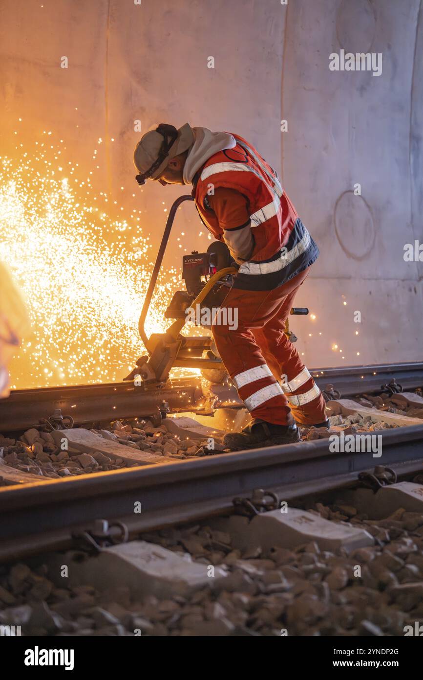 Construction worker grinding rails in a tunnel, sparks flying, rail ...