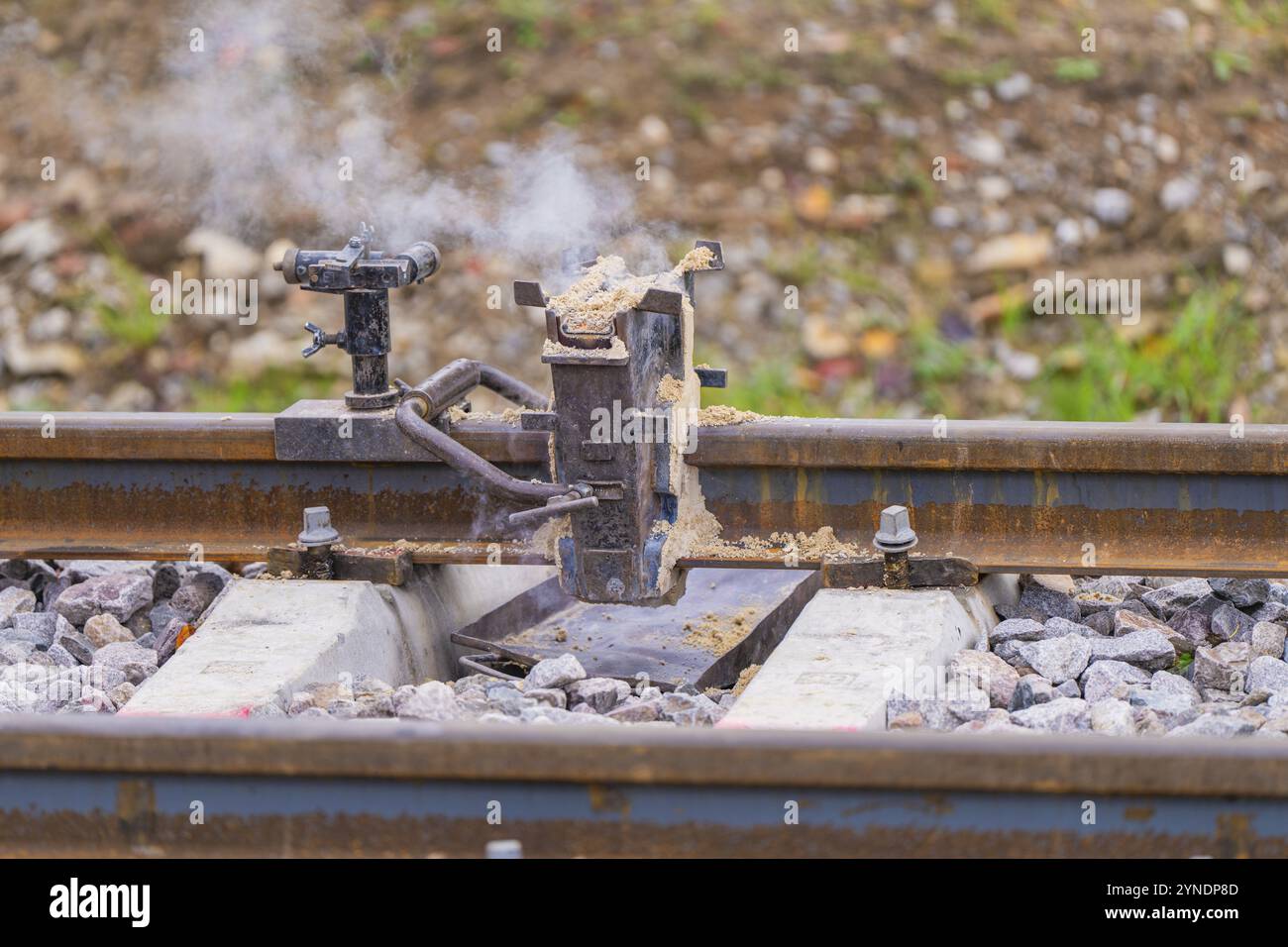 Metal fixture on the rails with rising smoke, rural environment, rail ...