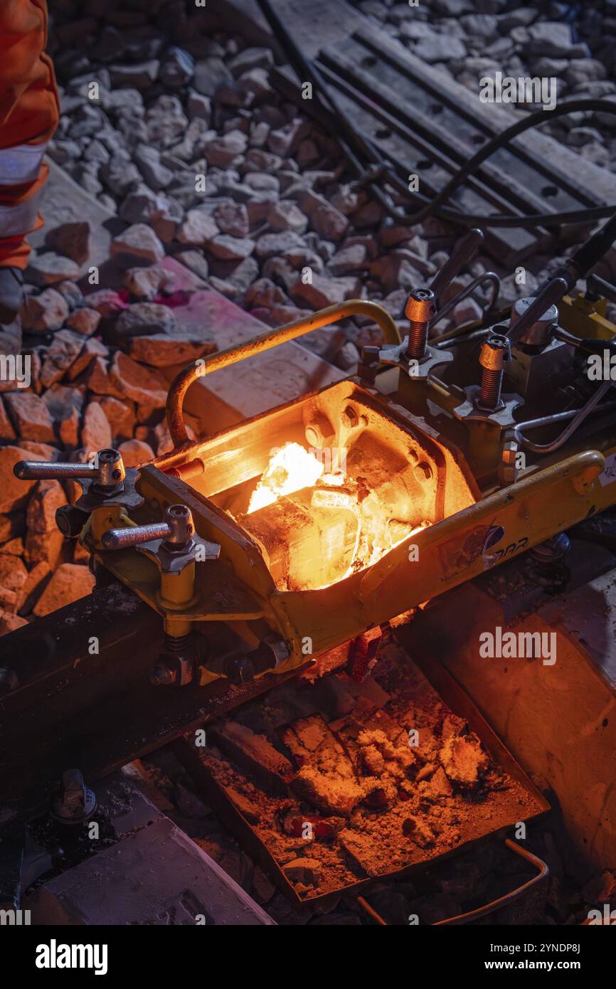 Close-up of welding work on rails in the dark with brightly illuminated ...