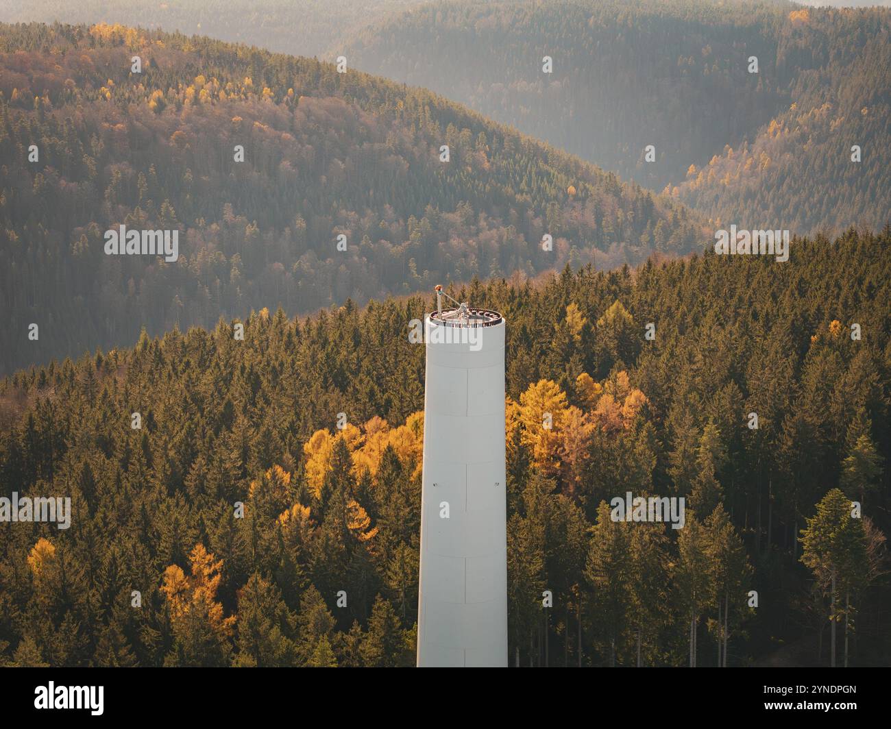 Autumn coloured hill with a wind turbine, surrounded by forest, wind ...