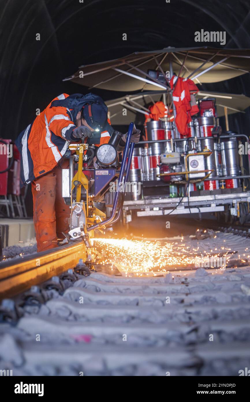 Worker welding a rail in a tunnel with flying sparks and large ...