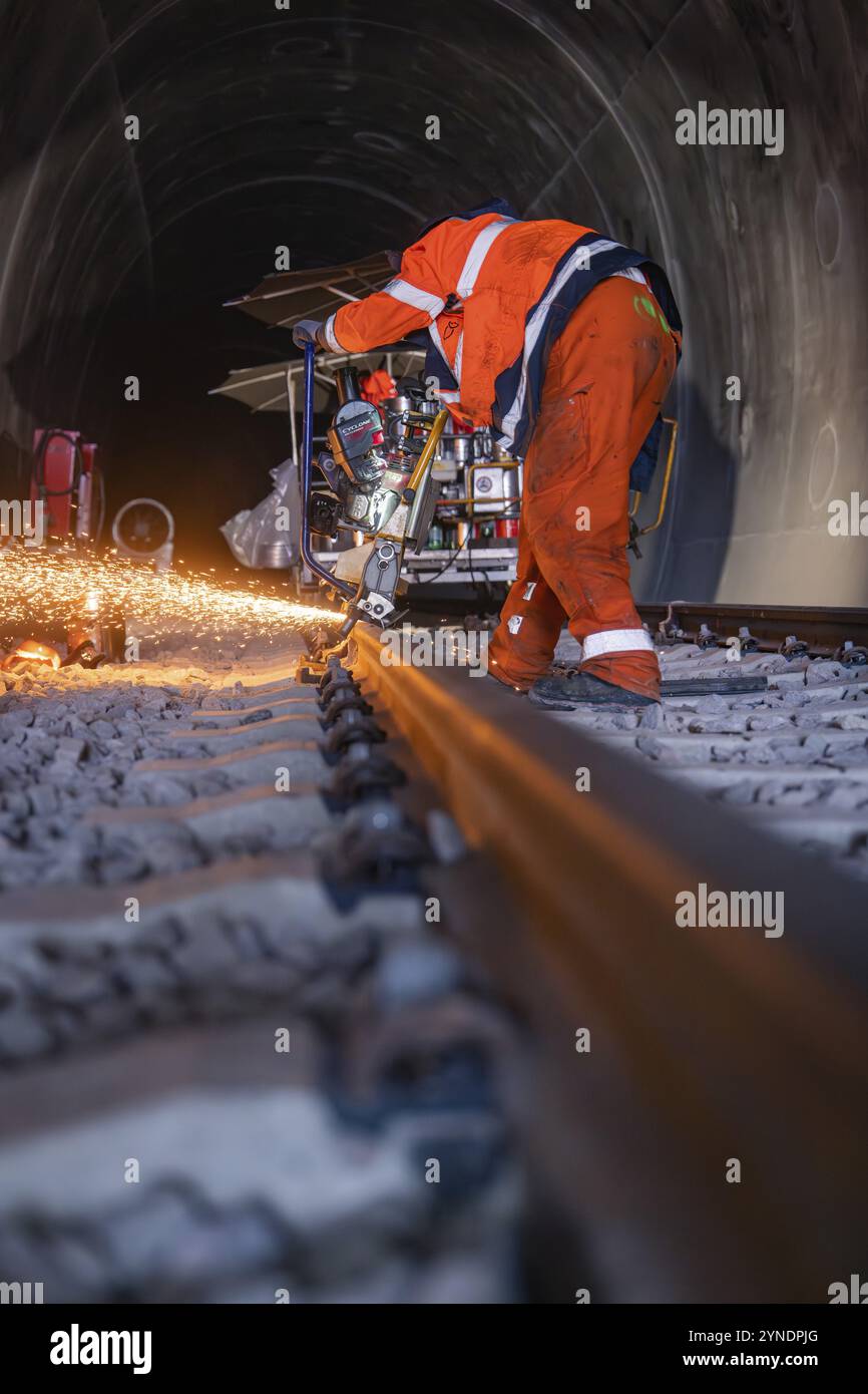 Worker welding on a rail in a tunnel while sparks fly, rail welding ...