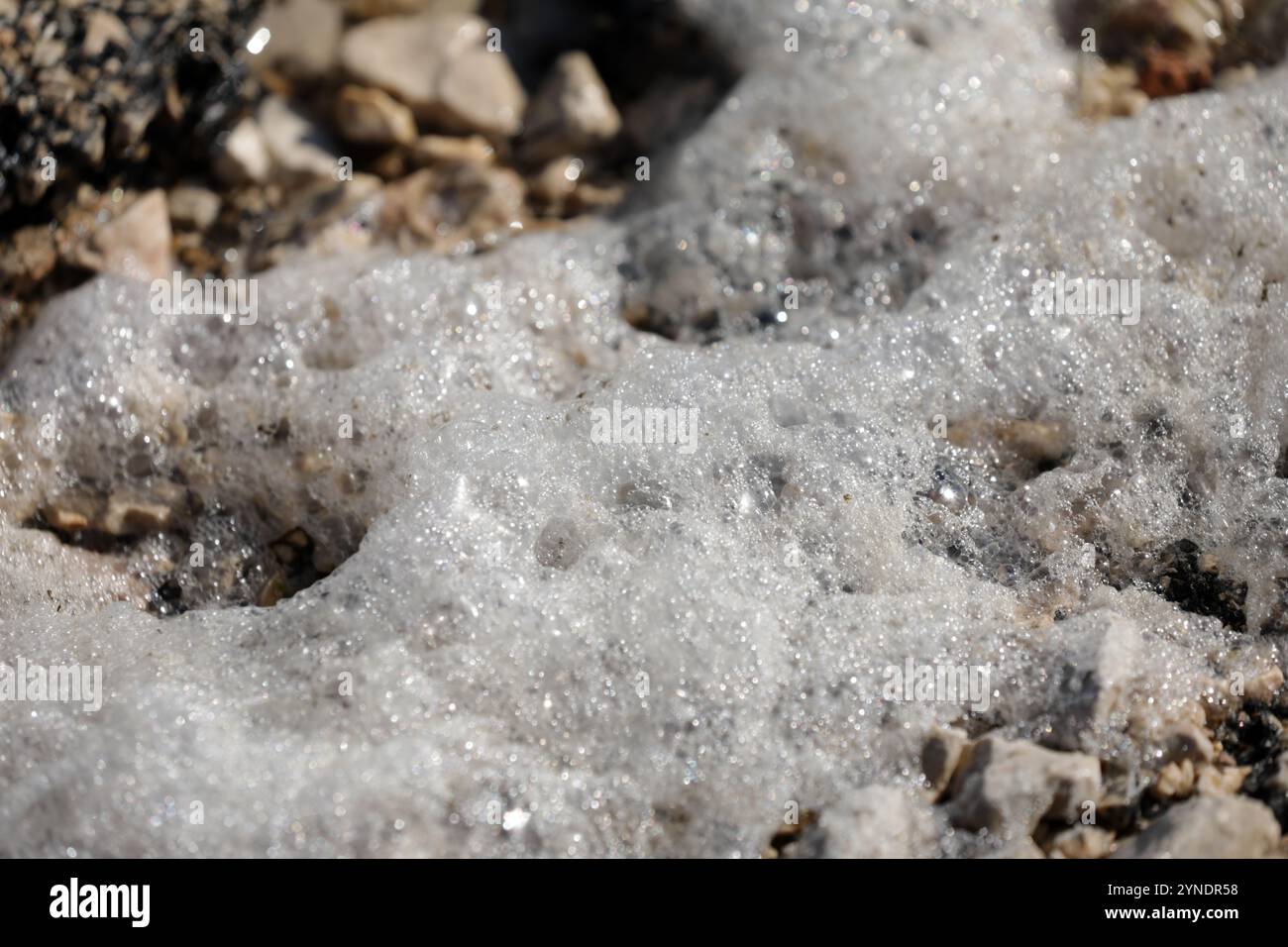 Beach by the sea with foam spray from the waves Stock Photo - Alamy