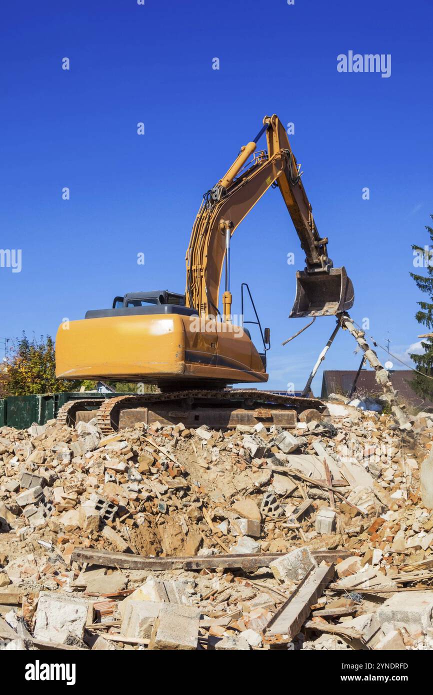 An excavator during demolition work on a house, building rubble ...