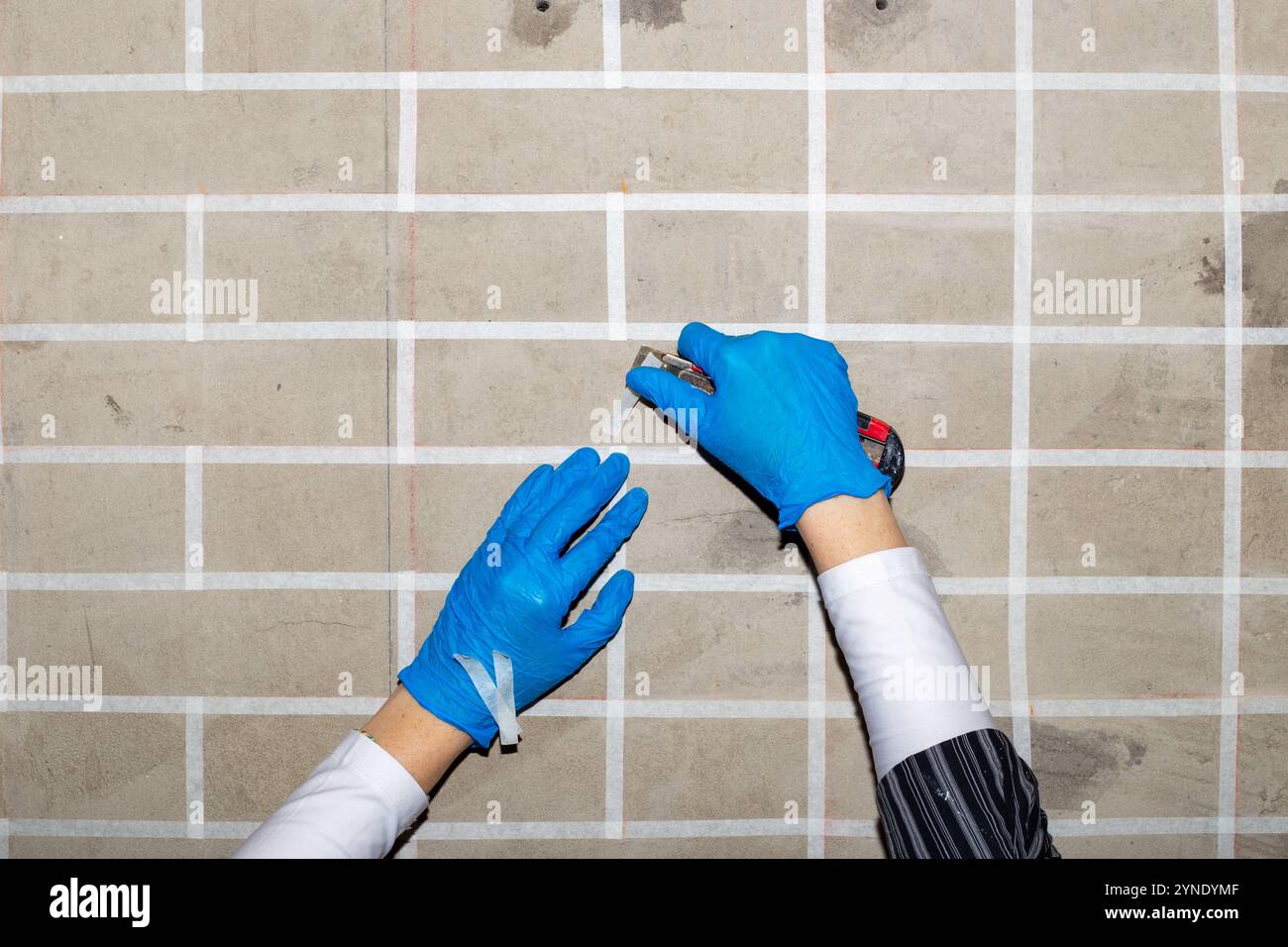 Decorative plaster bricks. A woman applies markings to a wall using ...