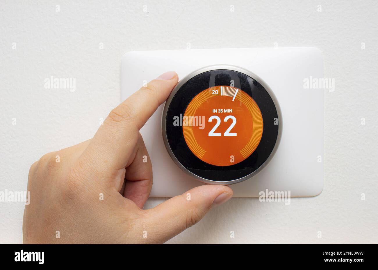 Smart Thermostat with a person warming up the room temperature with a ...