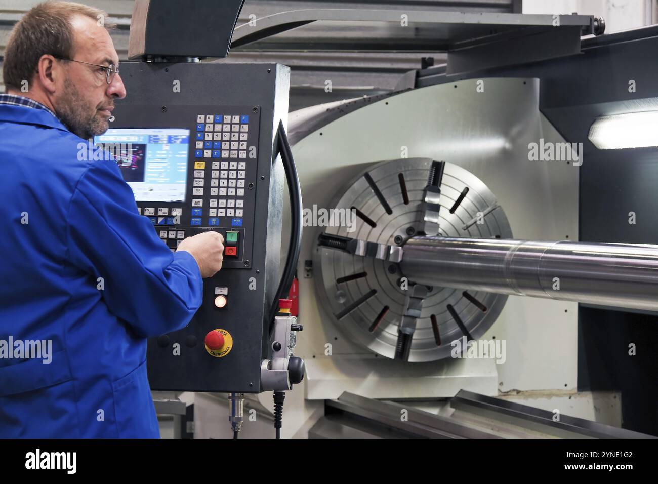 An older employee of the metal industry at CNC milling machine ...