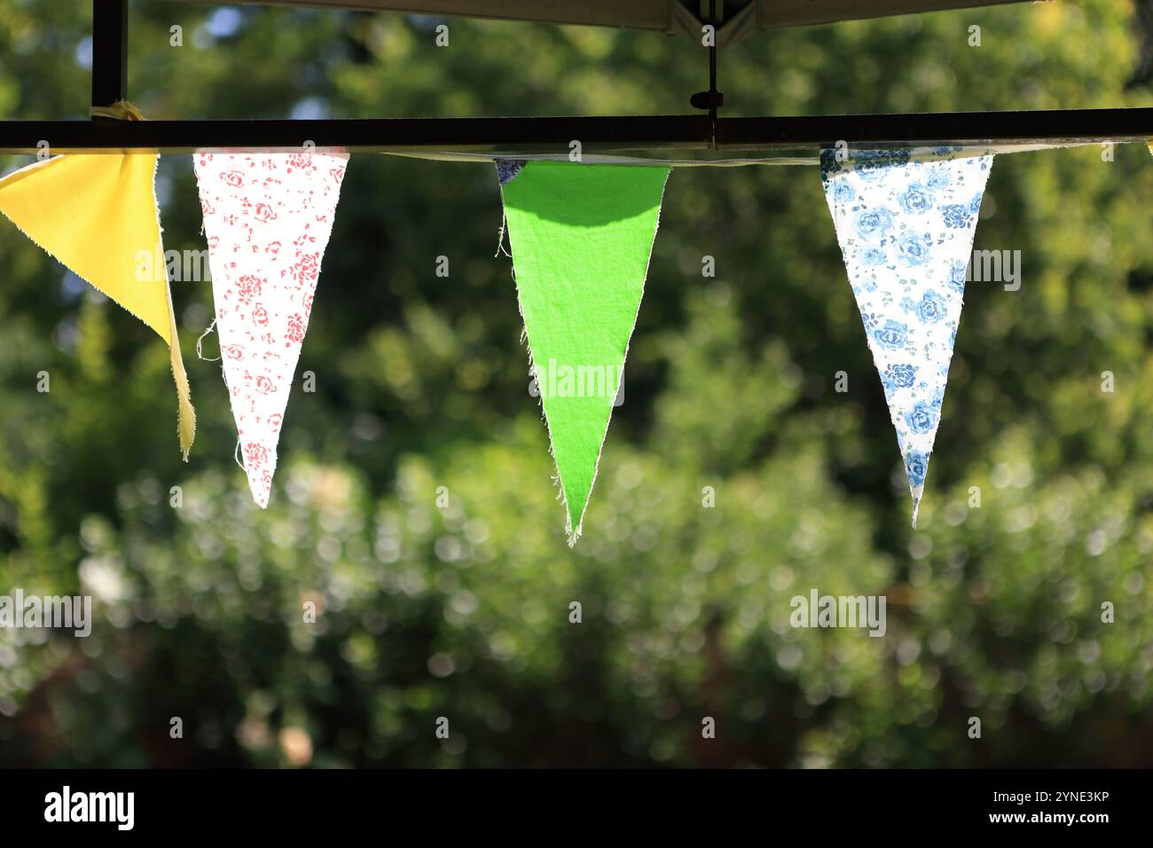 Triangular bunting made from fabric hanging in front of green ...