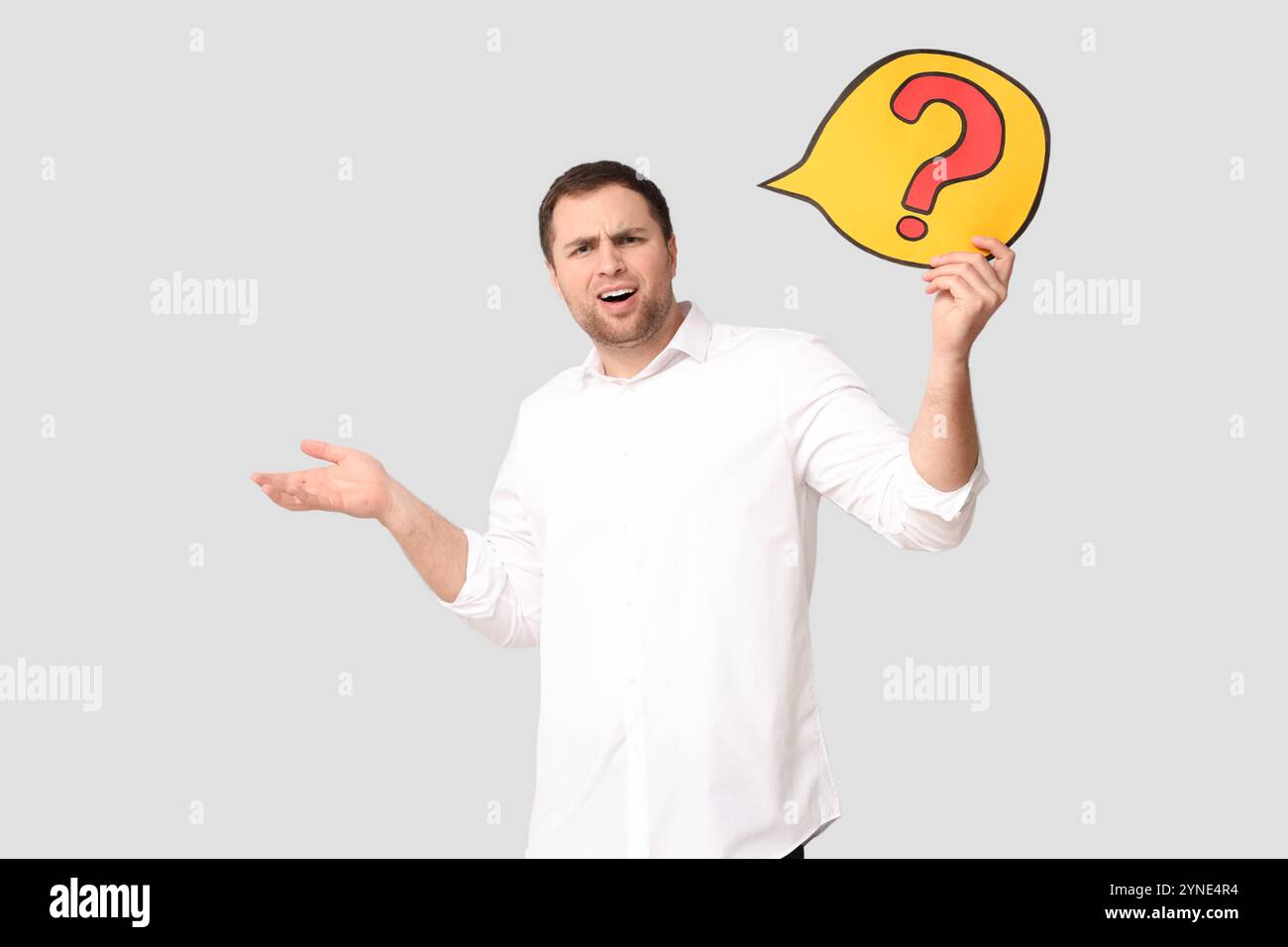 Confused young man with question mark on white background Stock Photo ...