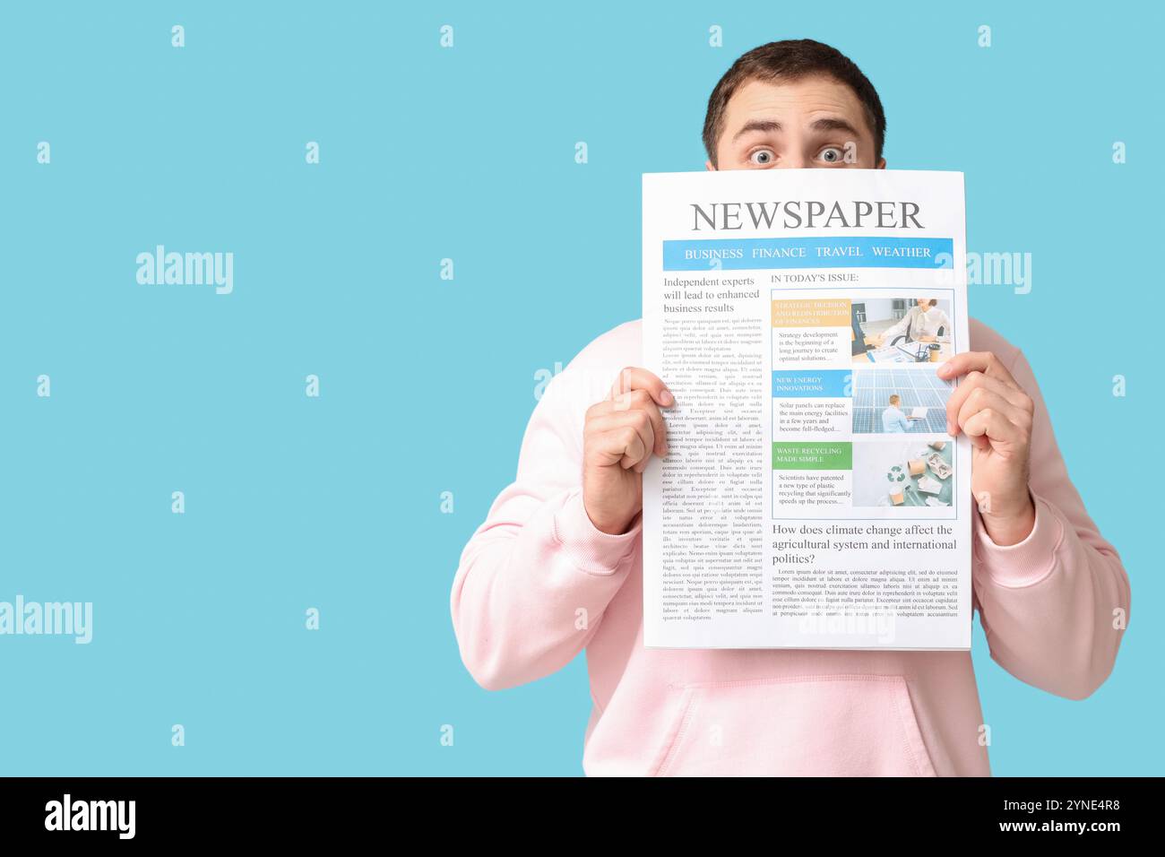 Shocked young man with newspaper on blue background Stock Photo - Alamy