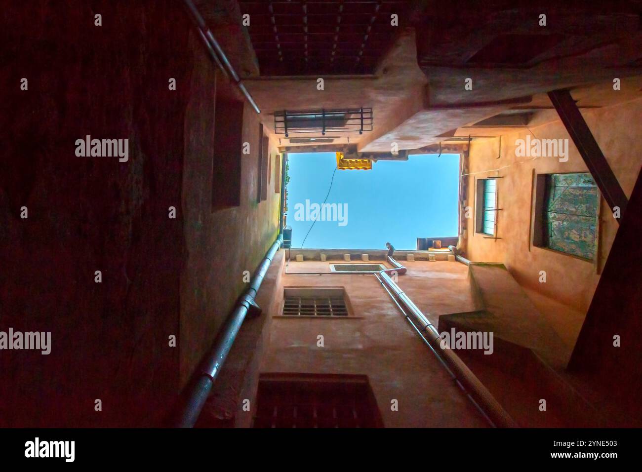 A striking upward view from a narrow alleyway in Venice, capturing the ...