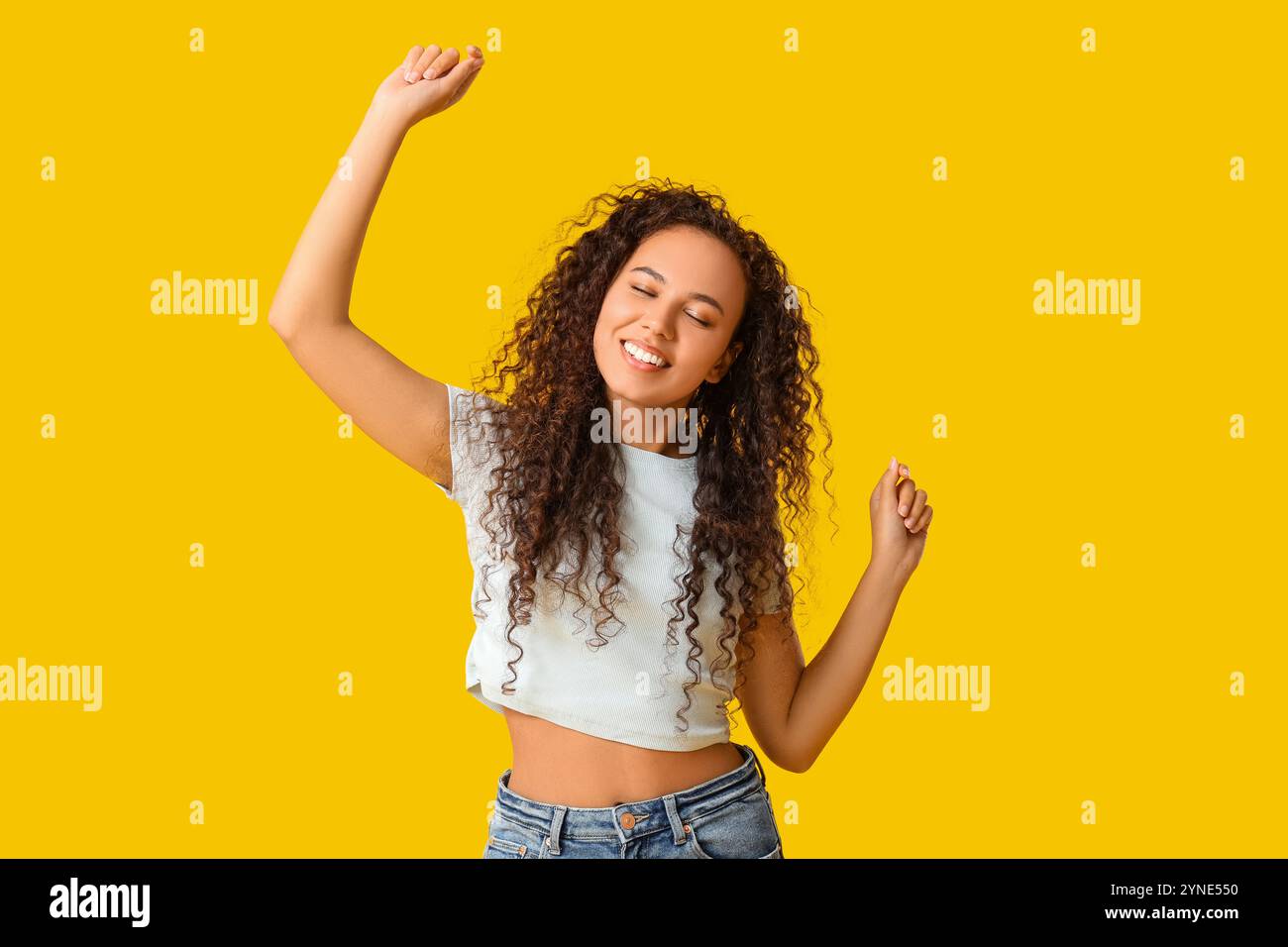 Beautiful young happy African-American woman dancing on yellow ... Beautiful young happy African-American woman dancing on yellow ...