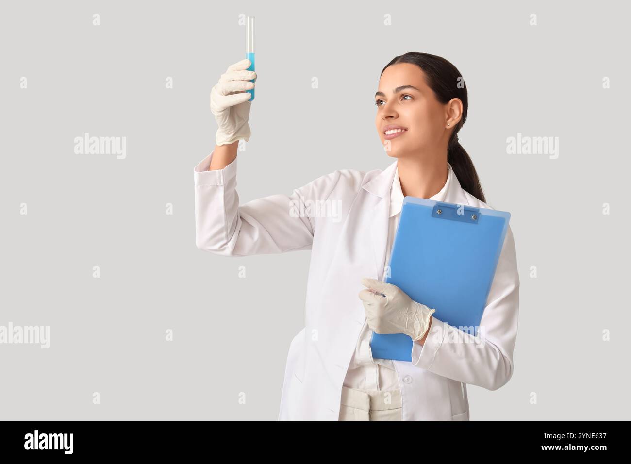Happy female young scientist with test tube of water sample and ...