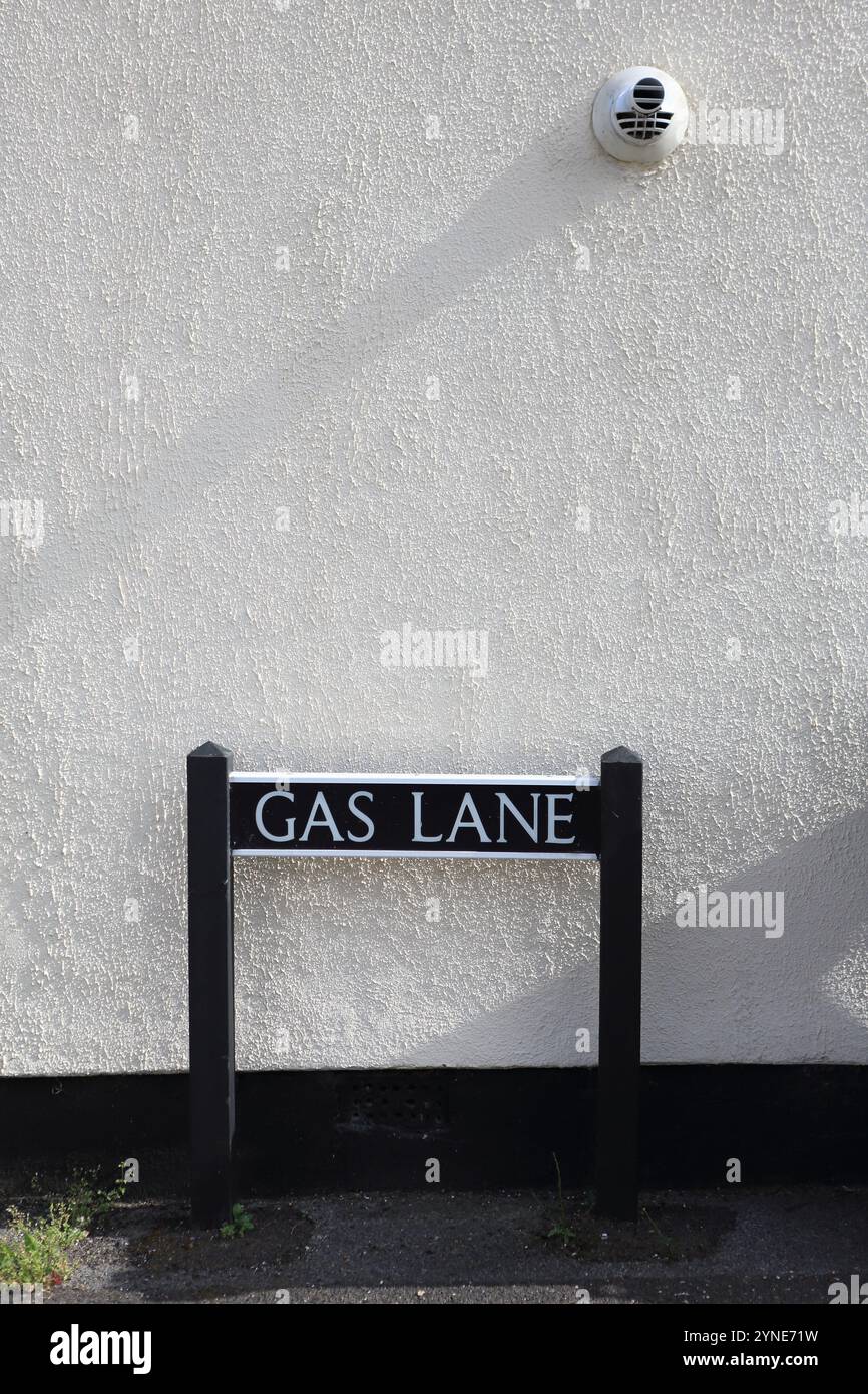 Gas Lane road sign with condensing boiler plastic flue in wall of house ...