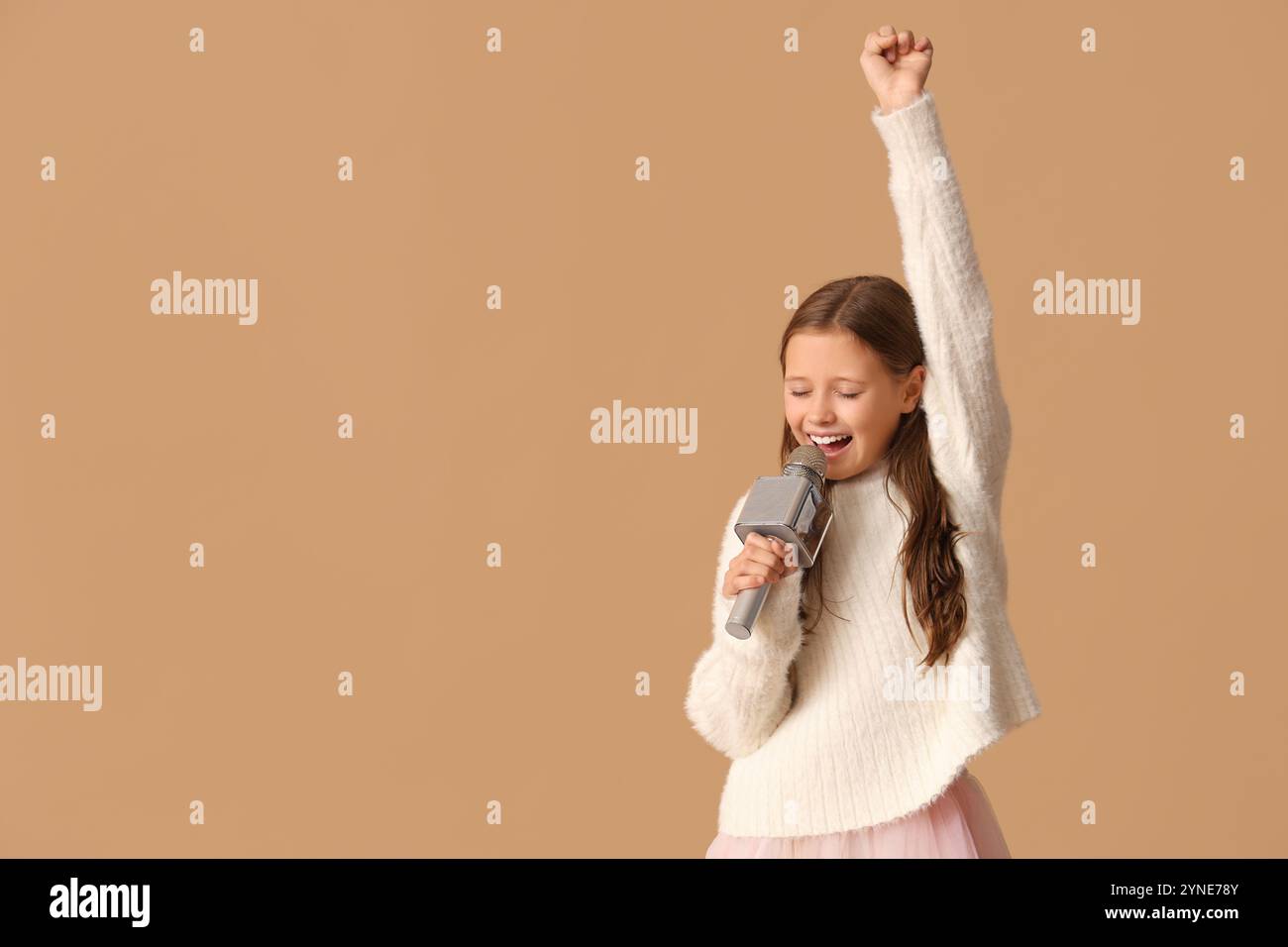 Cute girl singing with modern microphone on brown background Stock ...