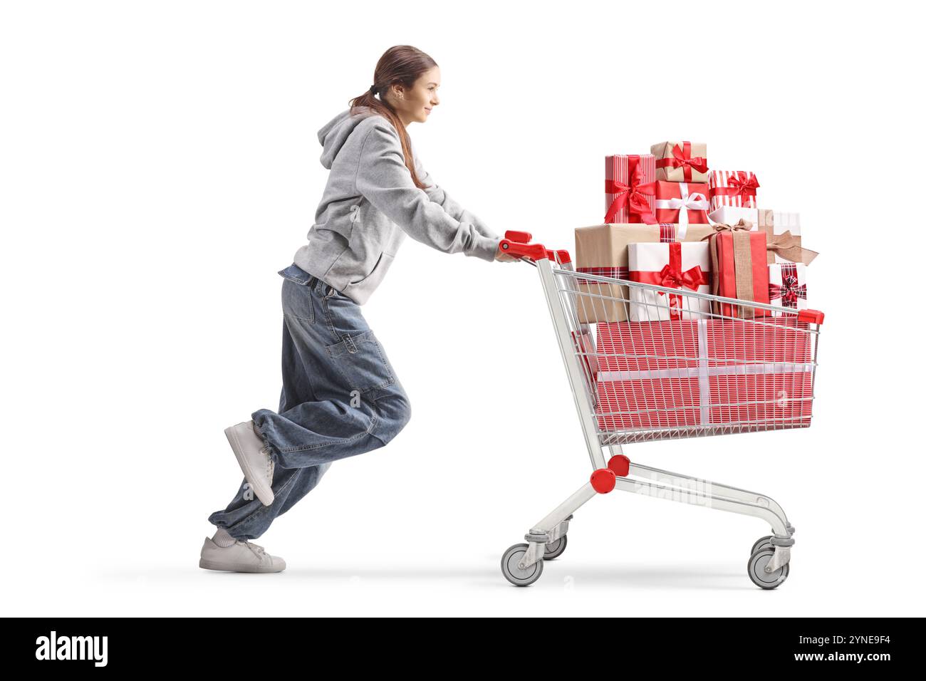 Teenage girl running with a shopping cart full of presents isolated on ...
