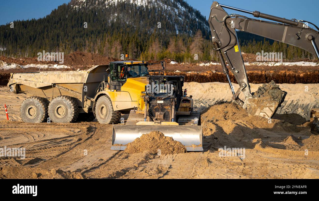 Bulldozer placing sand for the dumper road at the excavator loading ...