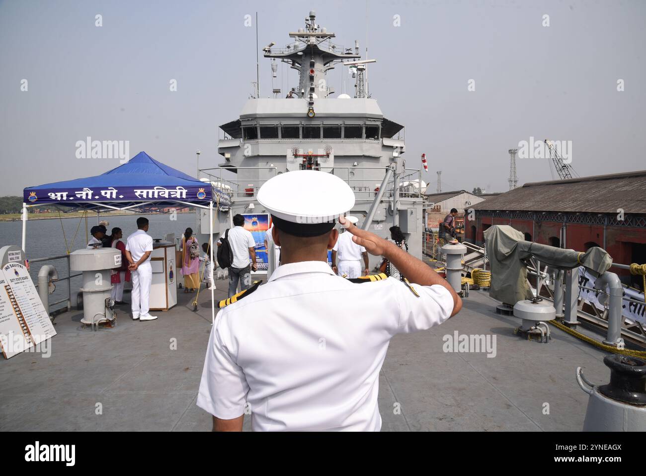 A Navy sailor salutes in front the Indian Navy's warship at INS Savitri ...