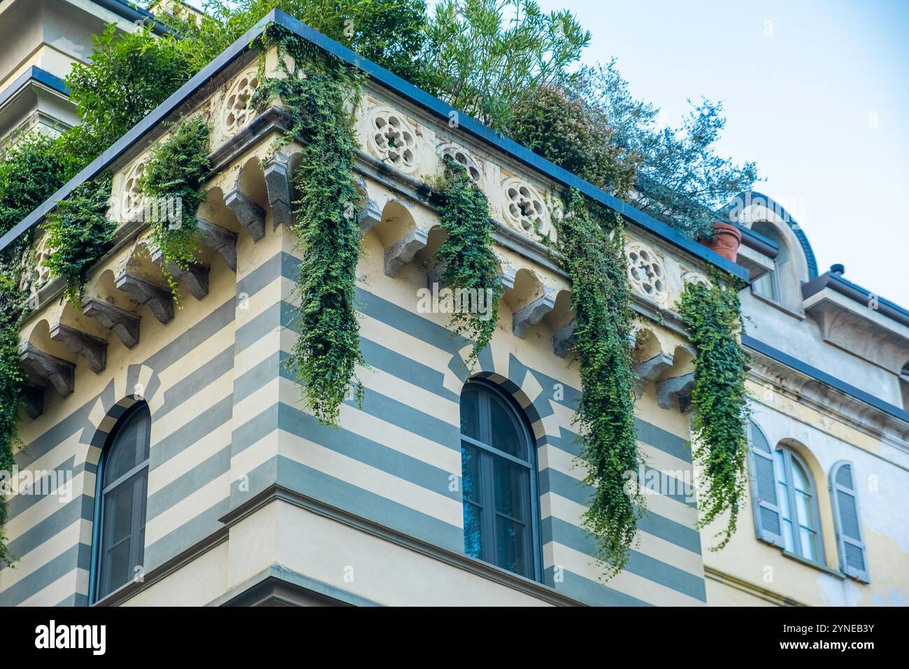 Historic building facade with striped pattern and hanging plants ...