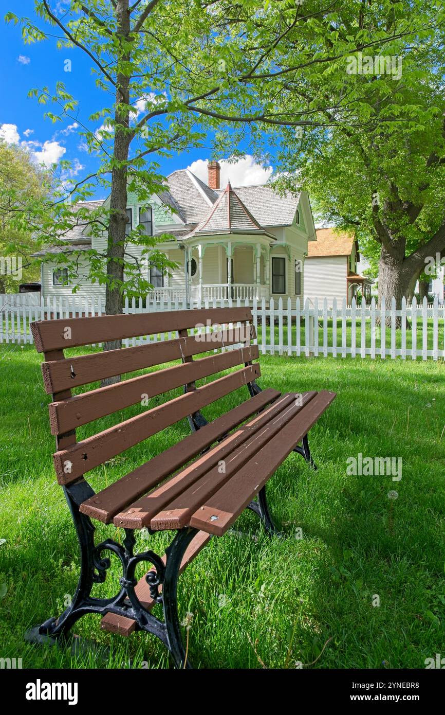 Park bench under fresh spring leafed trees in West Branch Iowa historic ...
