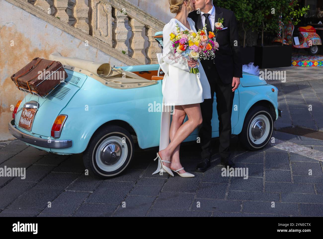 Daily life in Taormina, Sicily A newlywed couple kisses in front of a ...