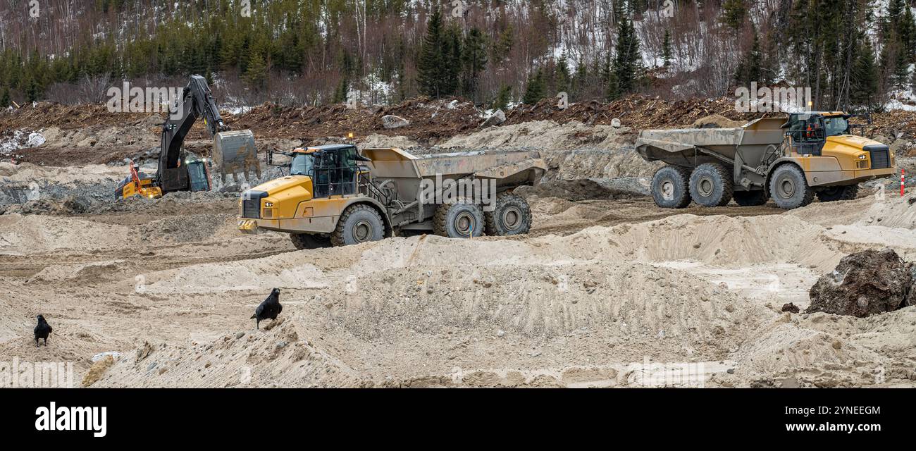 Two dump trucks in the loading area of an excavator Stock Photo - Alamy